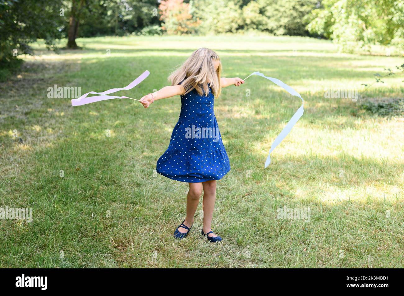 Full body anonymous girl in blue dress spreading arms with ribbons and ...