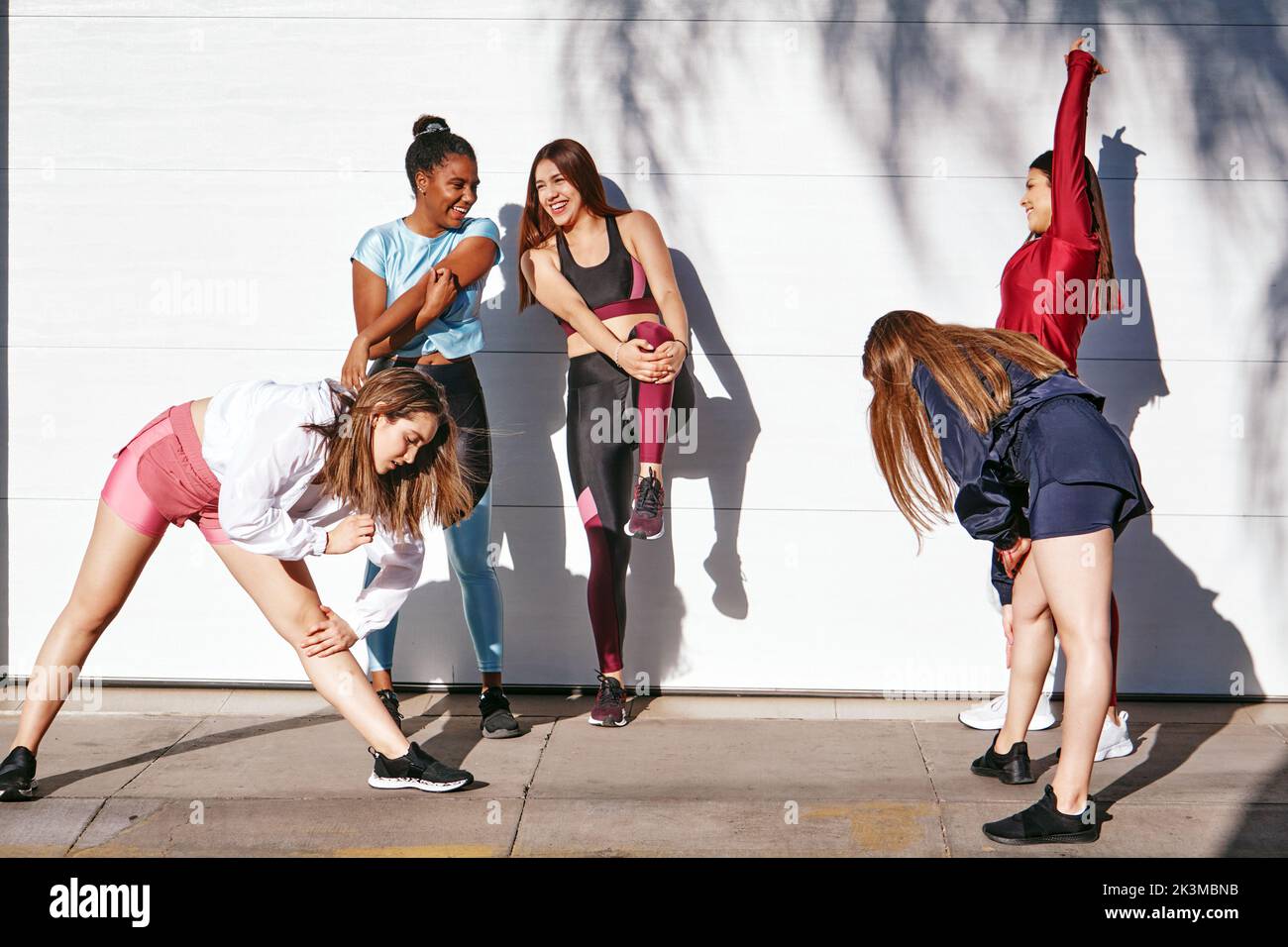 Group of cheerful young active multiethnic female friends in sportswear ...