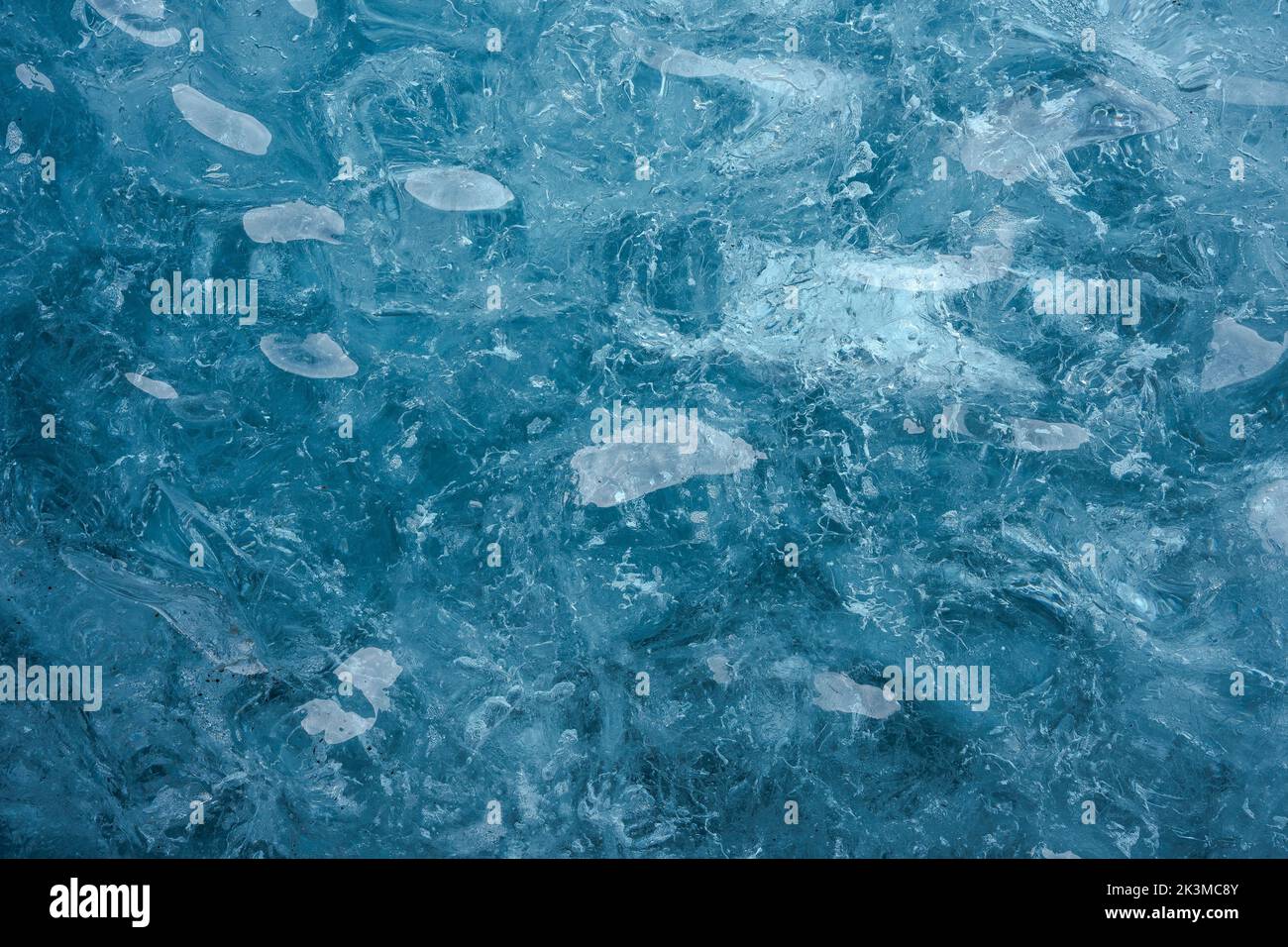 Clean blue water rippling near ice formations of glacier in Vatnajokull ...