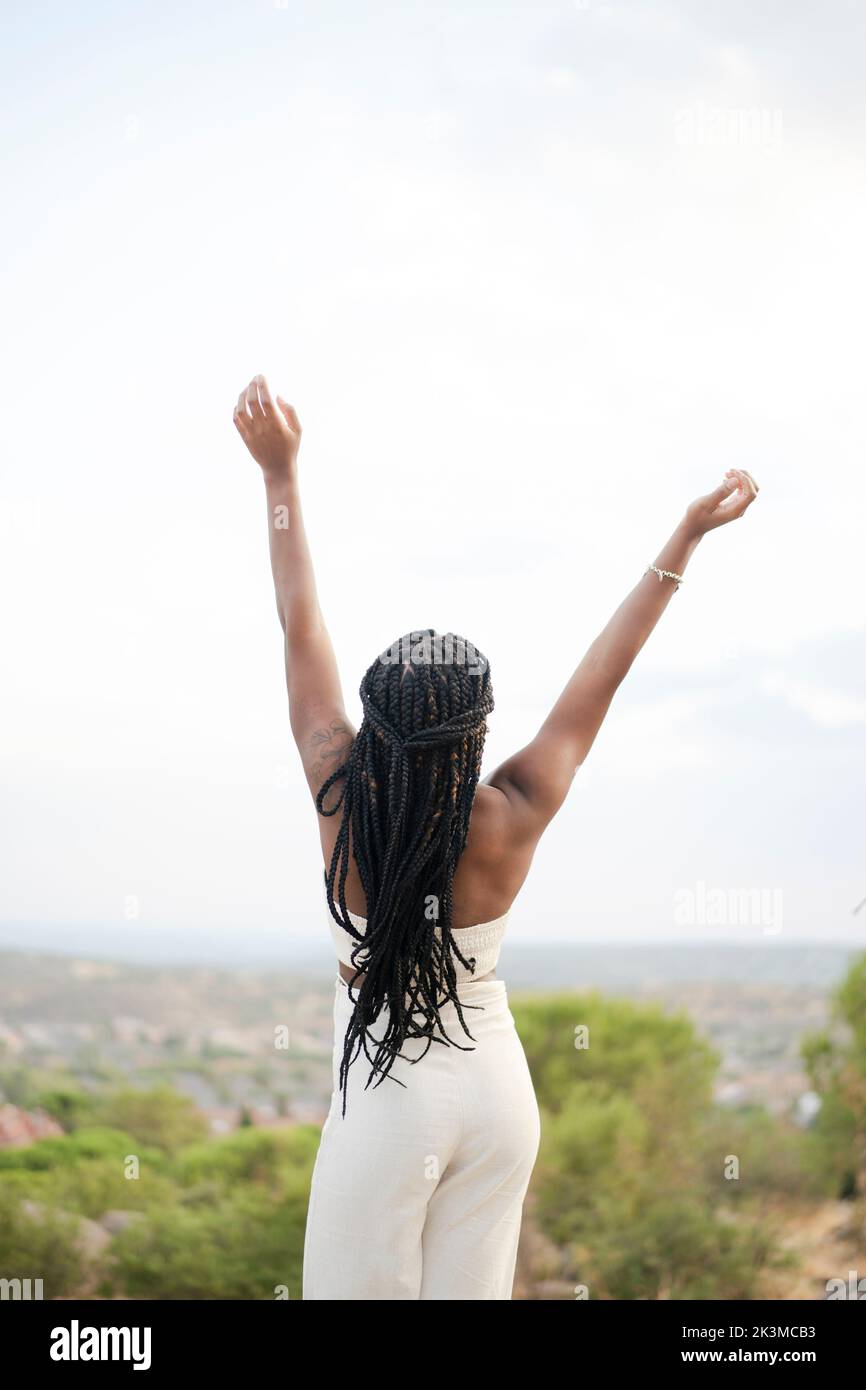 Back view of anonymous black female in white clothes with Afro braids ...