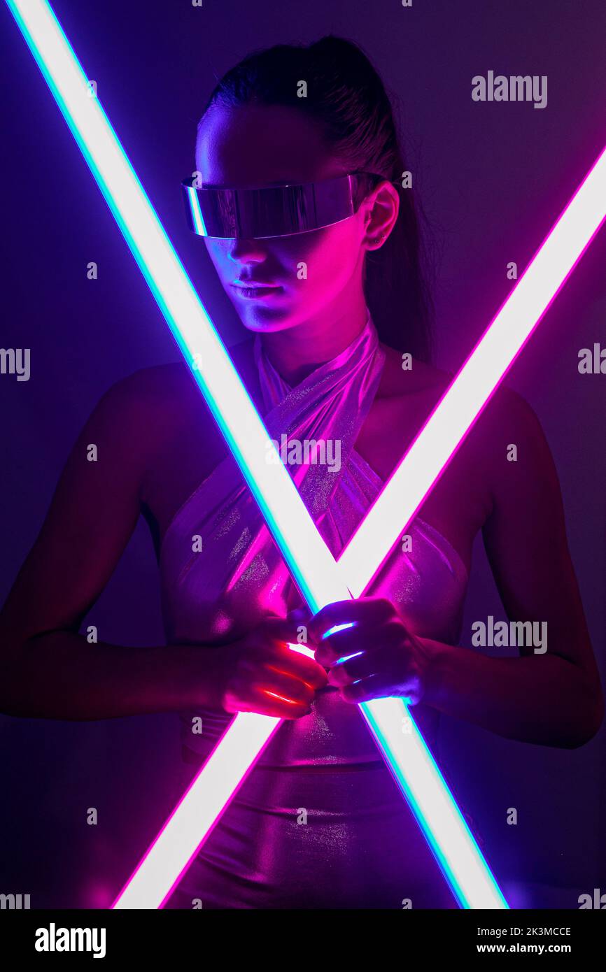 Self assured young female model with long hair in futuristic outfit and ...