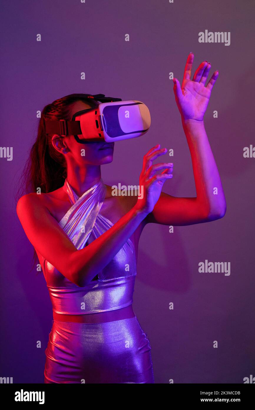 Unrecognizable young woman with long dark hair in futuristic outfit and ...