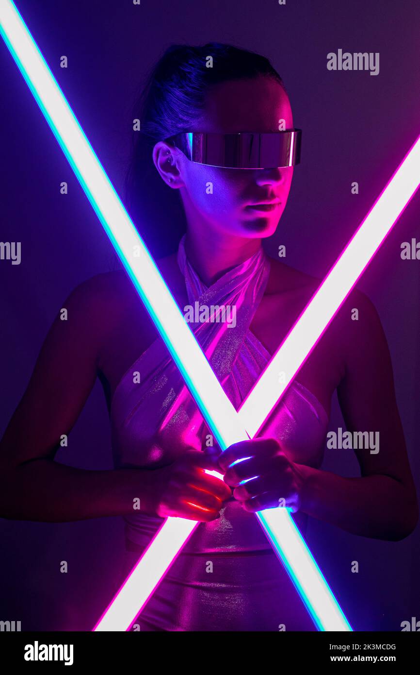 Self assured young female model with long hair in futuristic outfit and ...