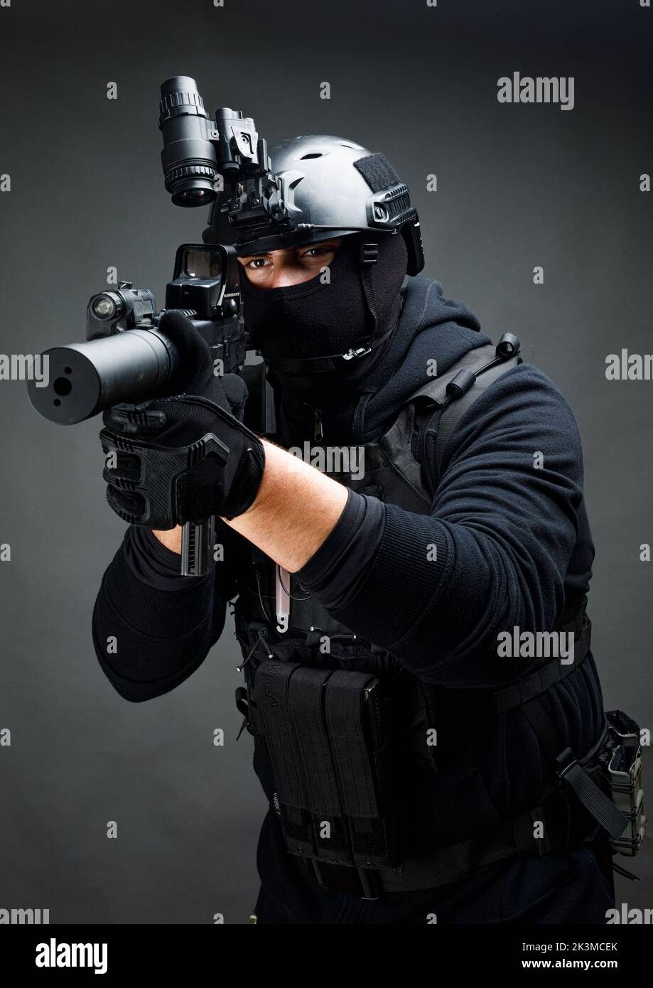 Unrecognizable concentrated male squad fighter in black protective gear ...