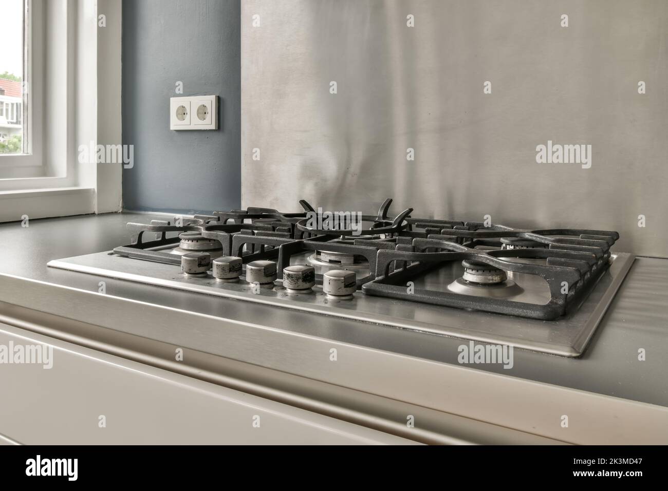 Gas cooker on wooden counter near glass window in light stylish kitchen ...