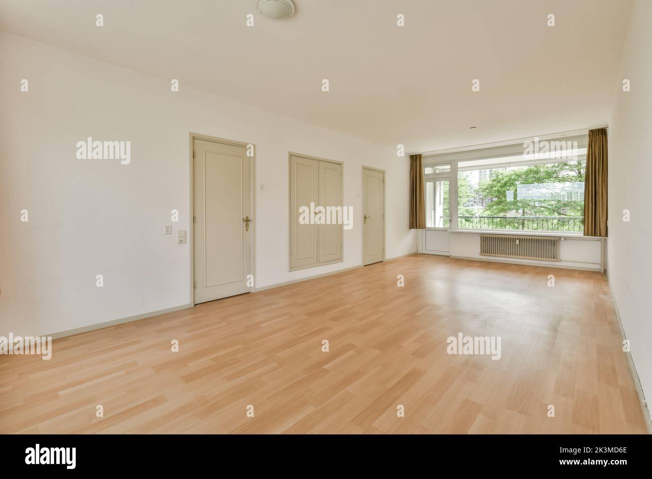 Interior of spacious empty old room with laminated floor with windows ...