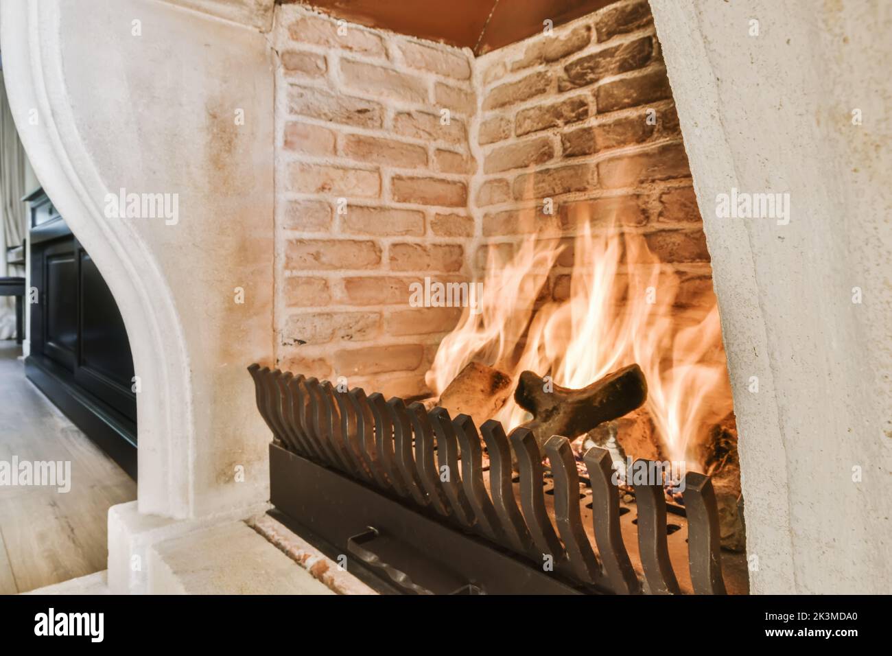 Side view of a lit indoor fireplace in a modern house Stock Photo - Alamy