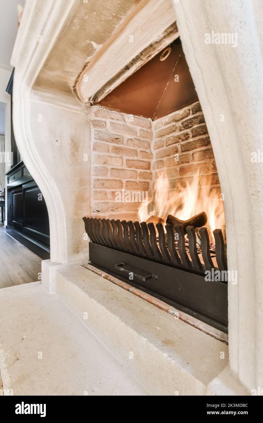 Side view of a lit indoor fireplace in a modern house Stock Photo - Alamy