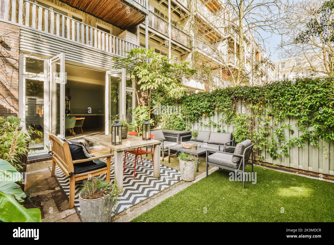 Backyard of a house with trees and green plants next to other houses ...