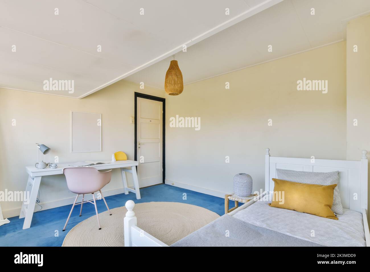 From above room with a desk by a door next to a bed and blue floor ...