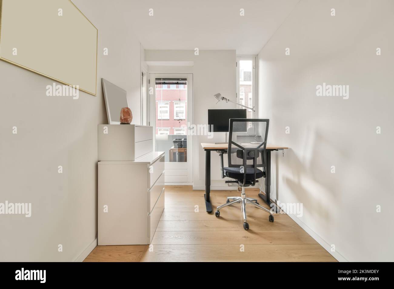 Interior of a room with a desk next to a window with white walls Stock ...