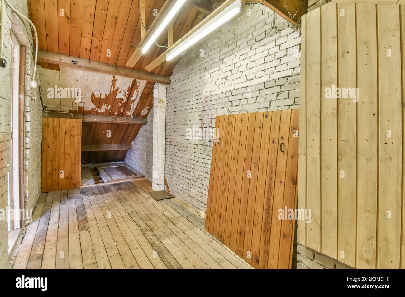 Empty storage room next to a wood door and parquet floor with lamps ...