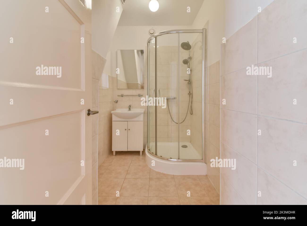 Interior of a sink with a shower closed with a screen next to a door ...