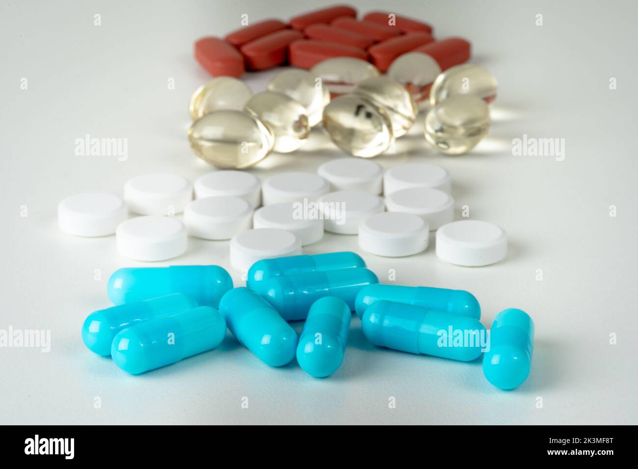 Groups of four kinds of pills on white surface Stock Photo - Alamy