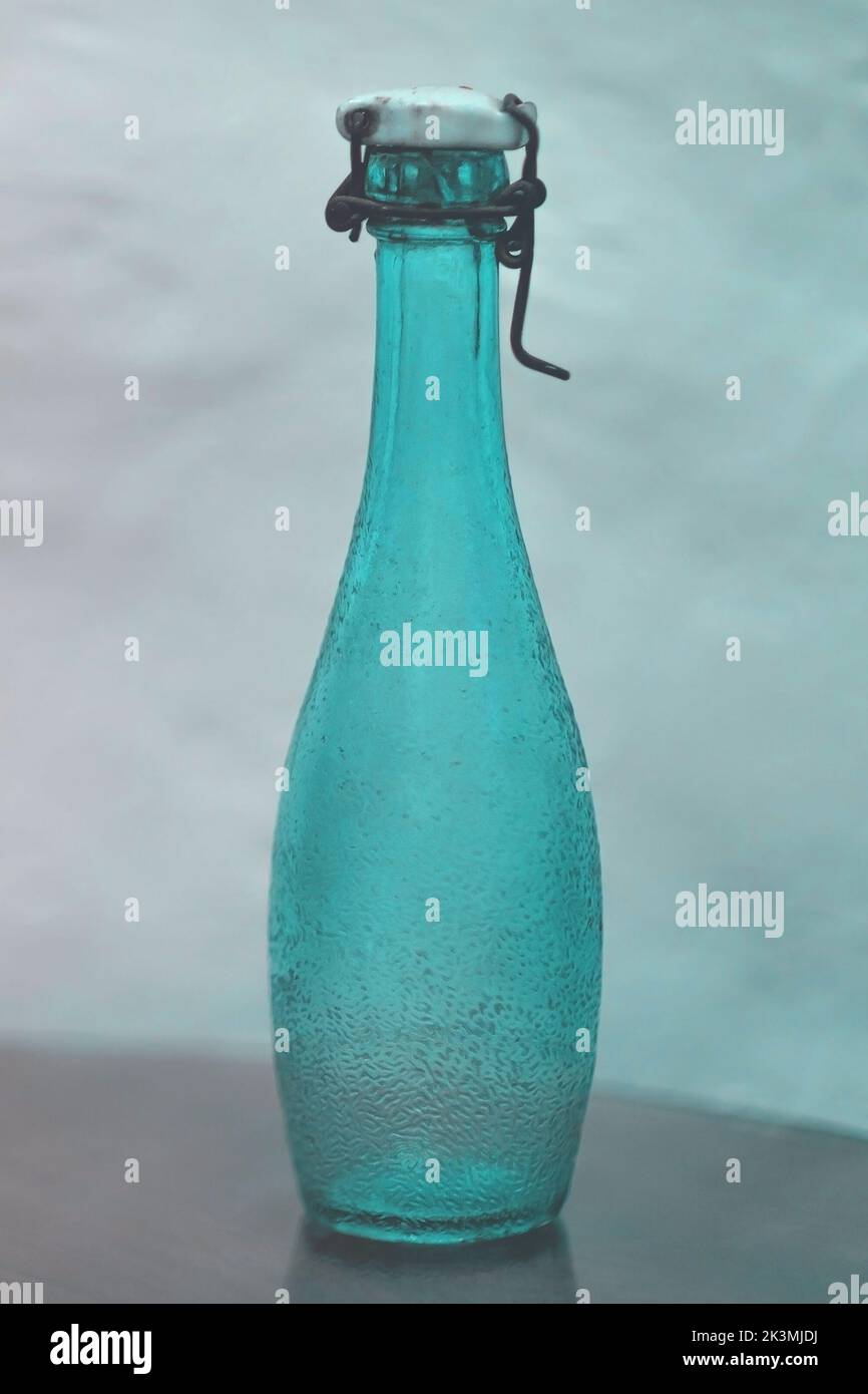 Empty Vintage Green Glass Bottle With Ceramic Lid And Wire Stopper On The Table Soft Focus