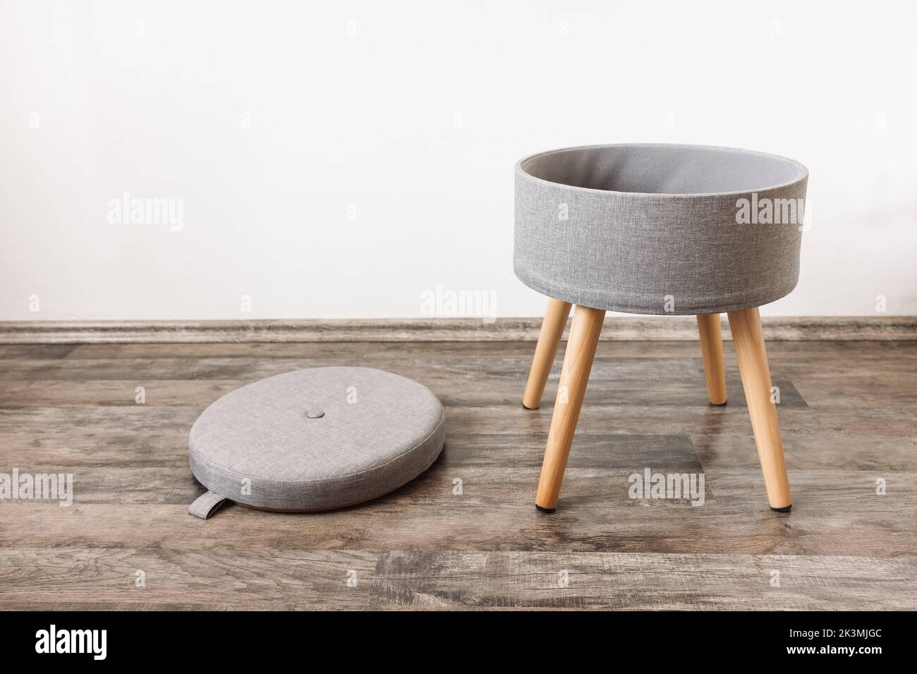 Trendy stool with and build-in storage space. Side view, white wall ...