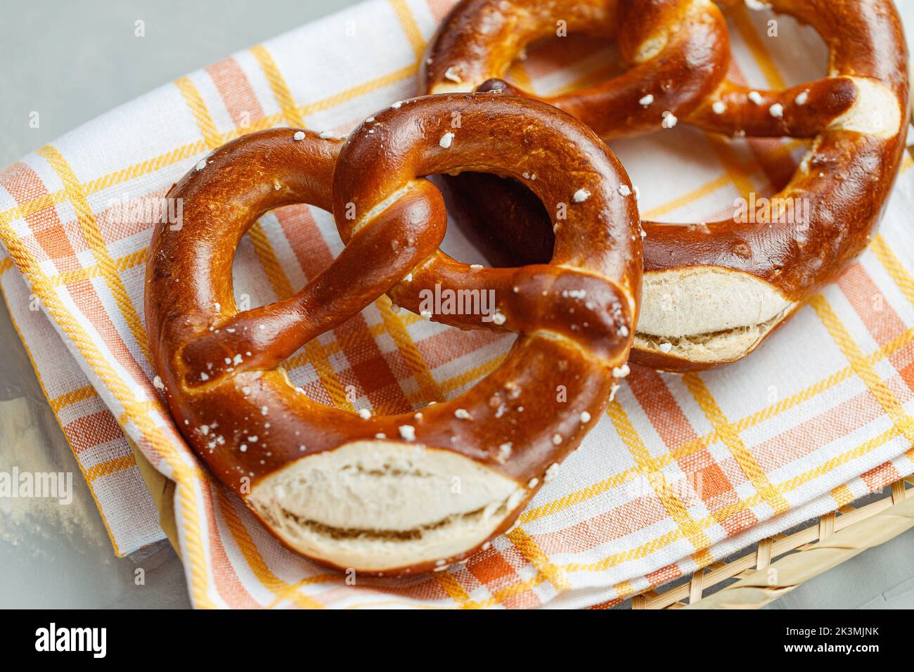 Two homemade freshly baked soft pretzels in bread basket with napkin ...