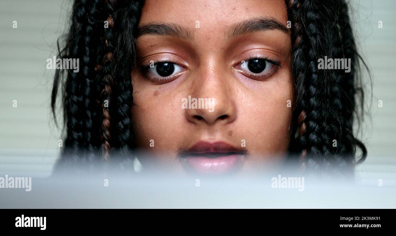Portrait hispanic black girl looking at computer screen face closeup ...