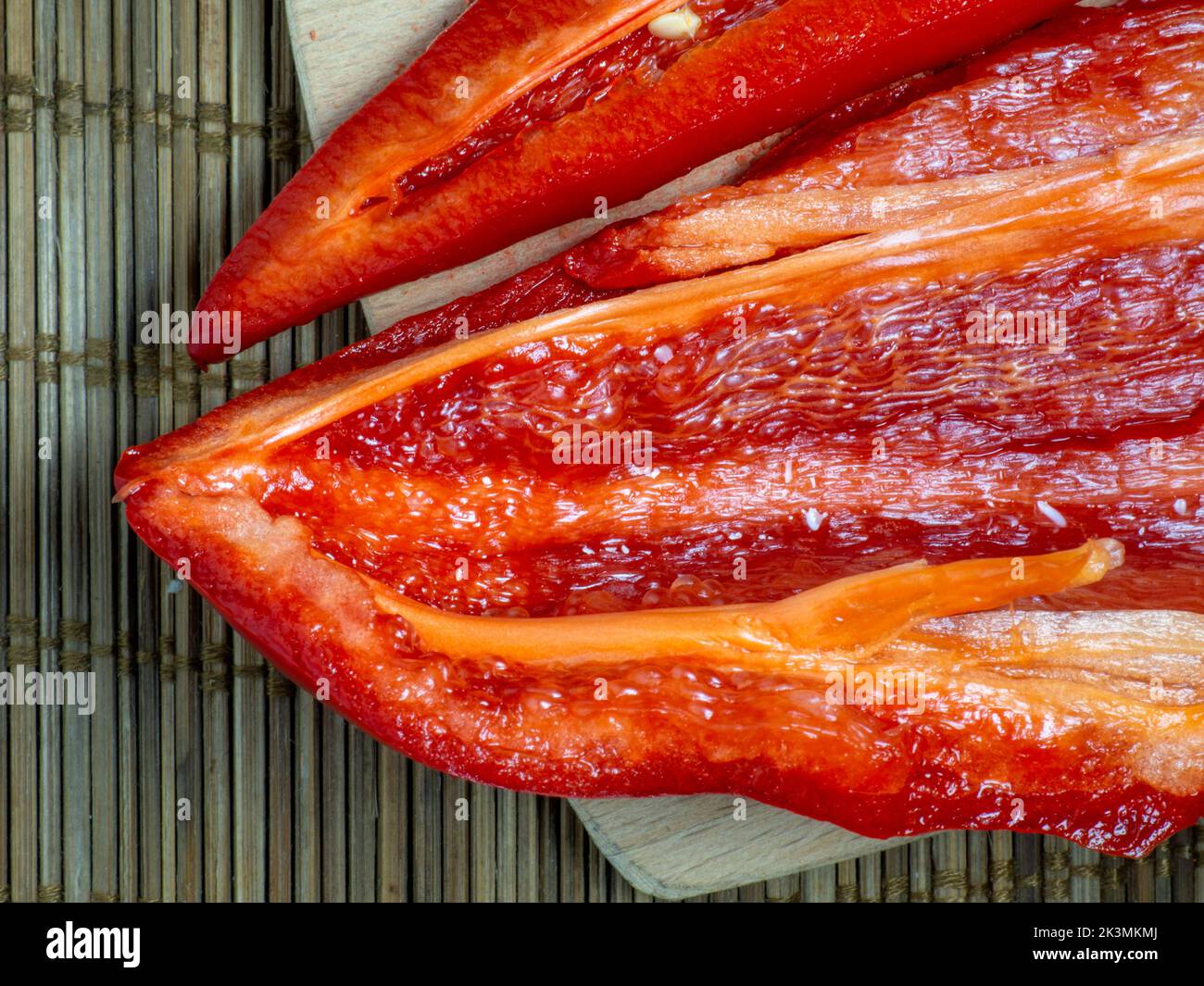 The pulp of long red sweet pepper on the kitchen table. Cut pepper ...