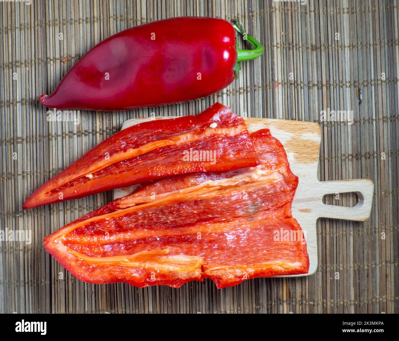 The pulp of long red sweet pepper on the kitchen table. Cut pepper ...