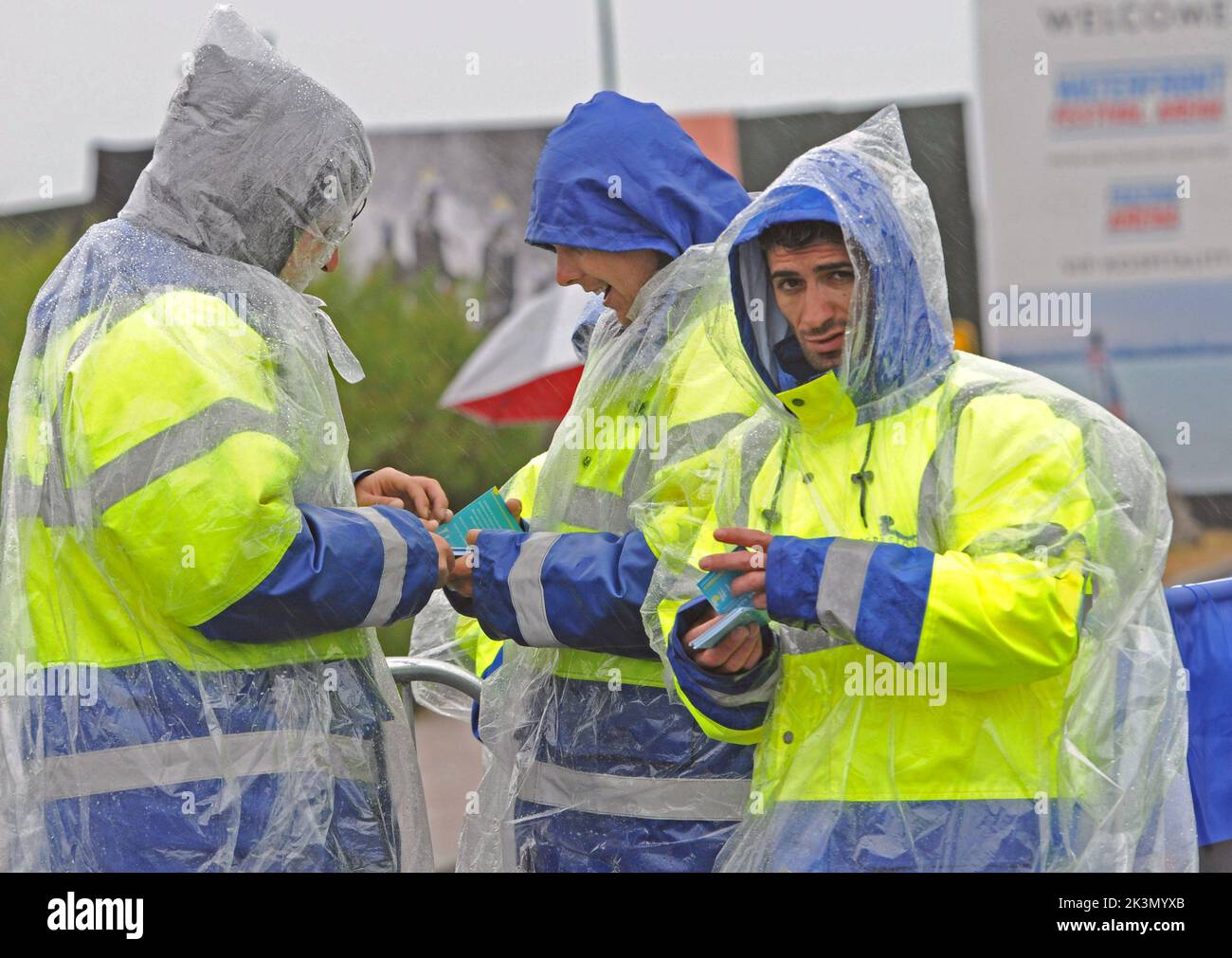 Rain sodden stewards check tickets for visitors to the Americas Cup on ...