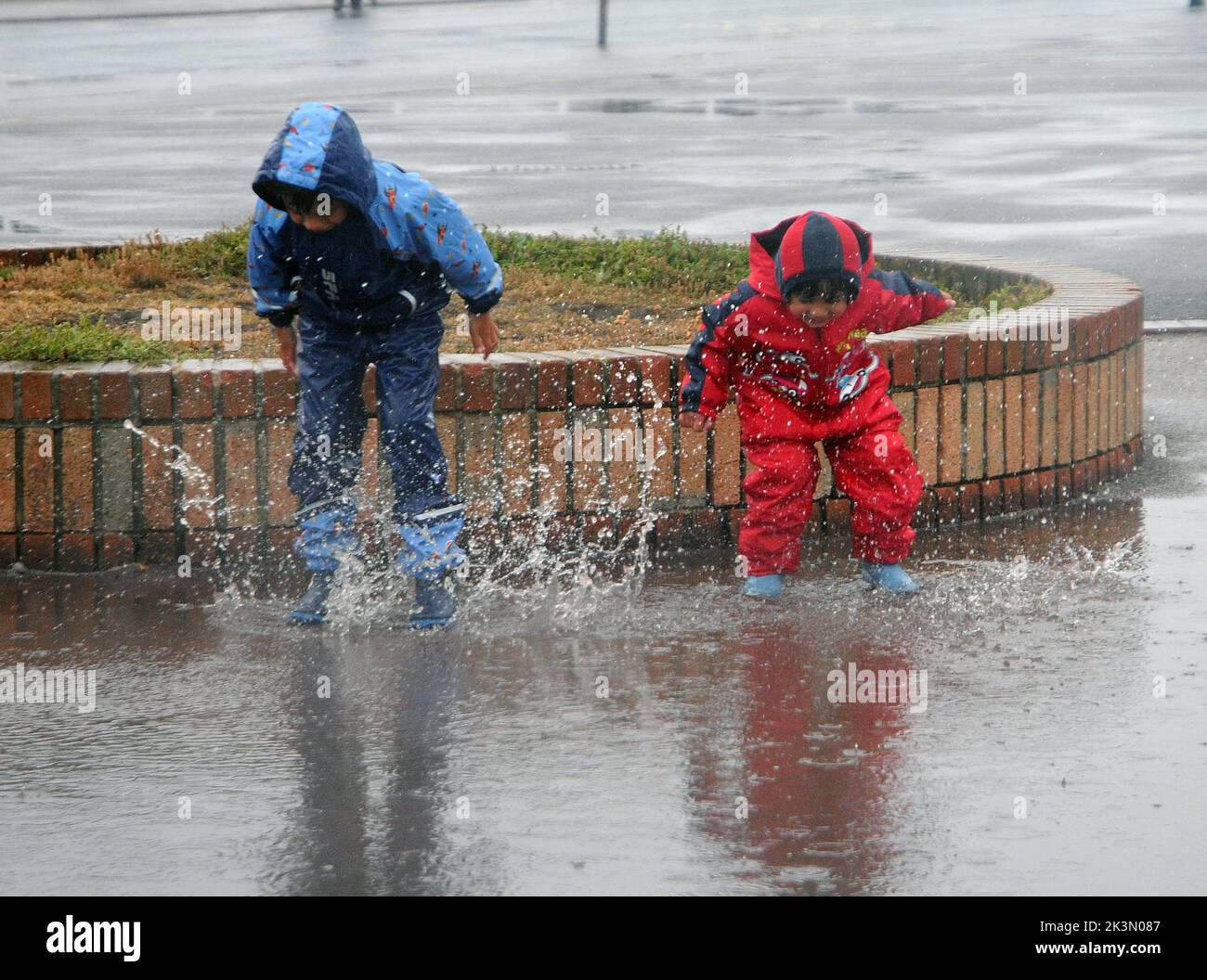 Youngsters splash in the puddles at the Americas cup in the rain on the ...