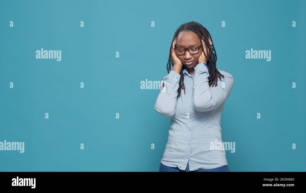 Young adult dealing with painful headache in studio, showing burnout ...