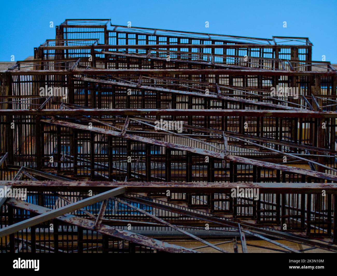 A low-angle shot of the exterior of a building with fire escape stairs ...