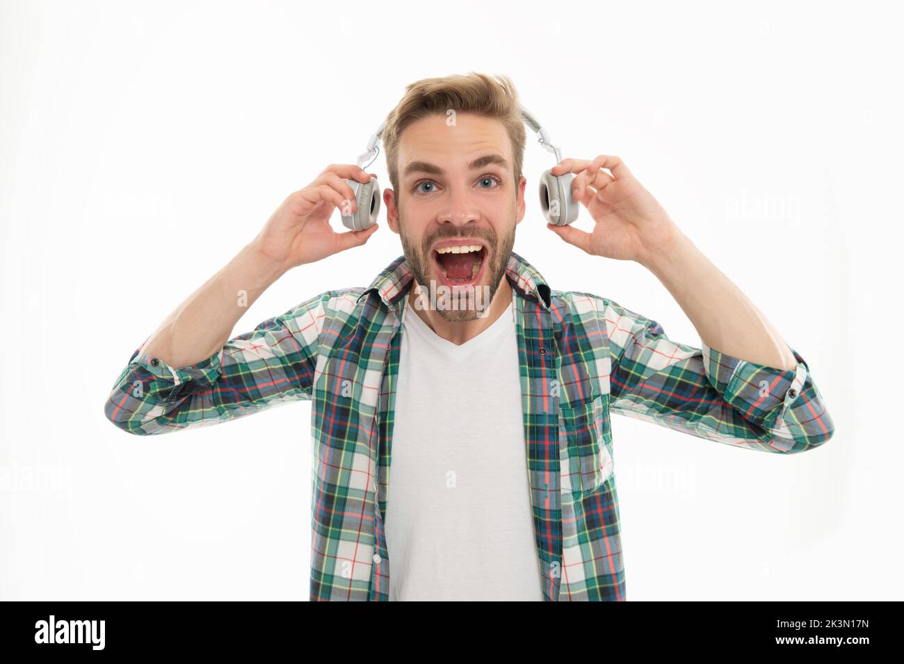 Shocked man taking off headphones. Amazed man keeping jaw dropped ...