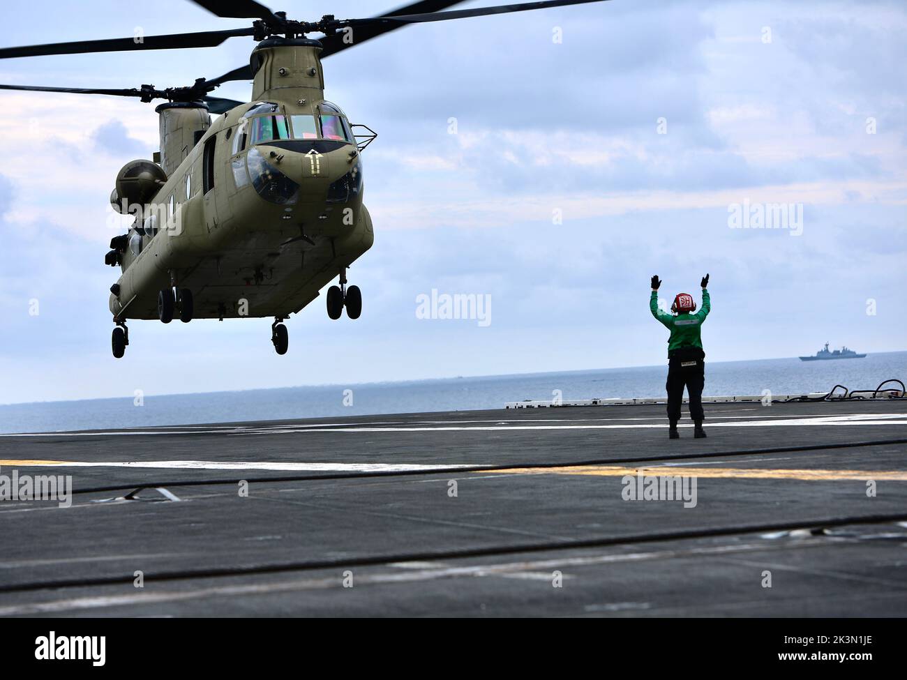 A U.S. Navy Sailor assigned to the USS Ronald Reagan (CVN 76), guides a ...