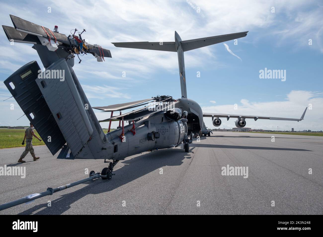 An HH-60G Pave Hawk helicopter is loaded into the back of a C-17 ...