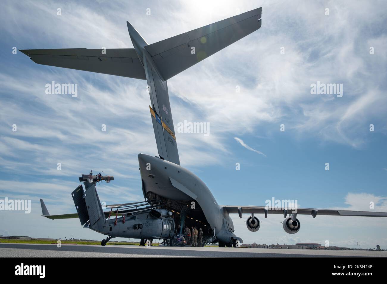 An HH-60G Pave Hawk helicopter is loaded into the back of a C-17 ...