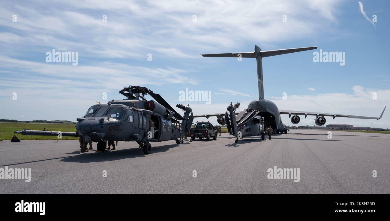 Two HH-60G Pave Hawk helicopters wait to be loaded into the back of a C ...
