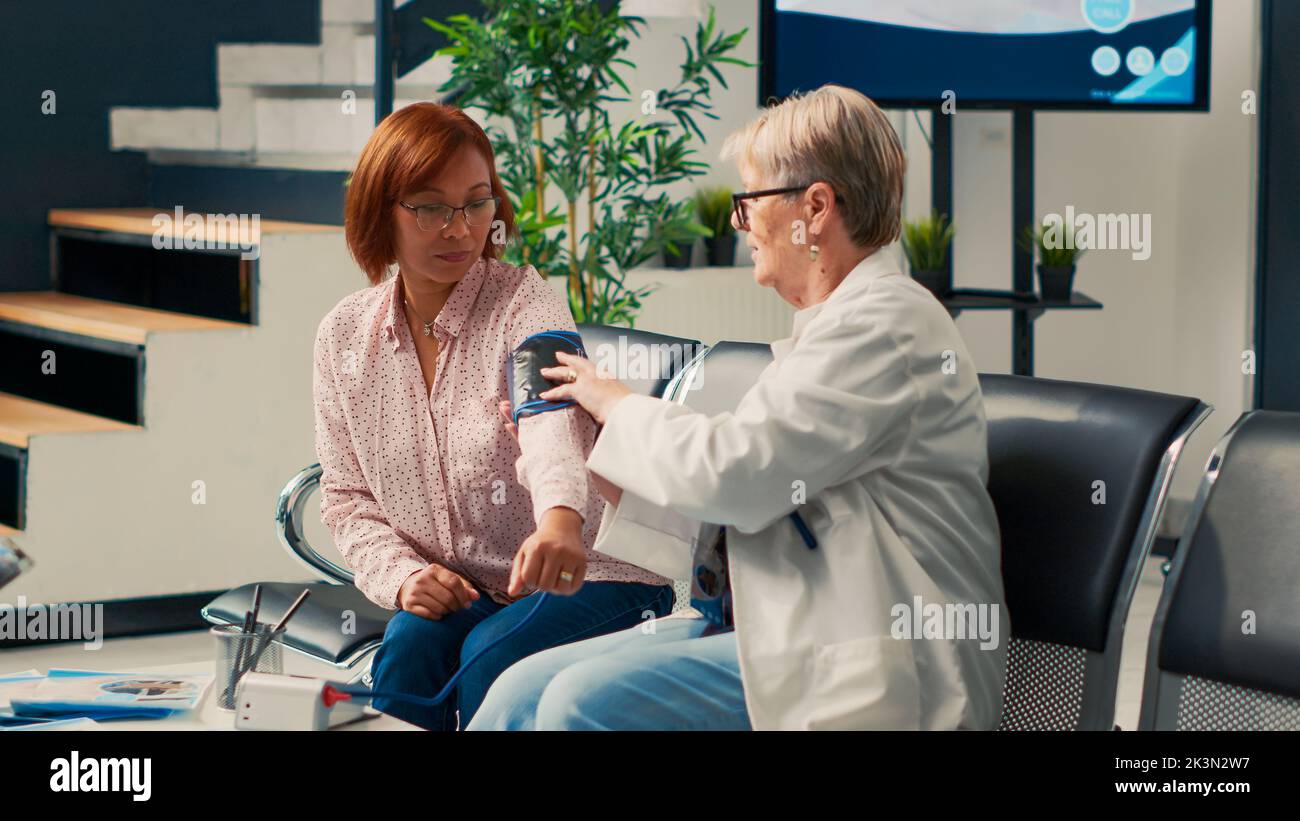 Health specialist measuring hypertension and blood pressure to do heart ...