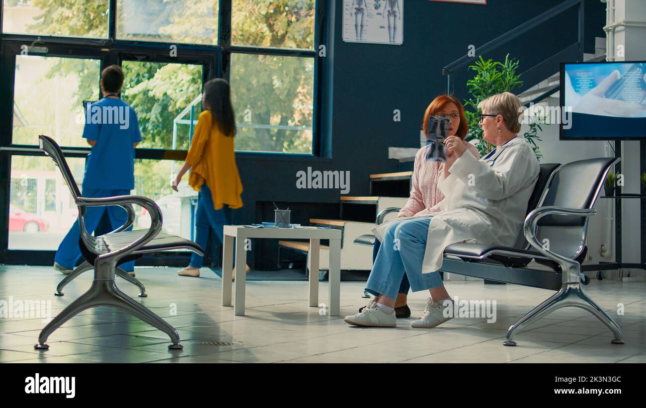 Senior medic explaining x ray scan bones diagnosis to patient in ...