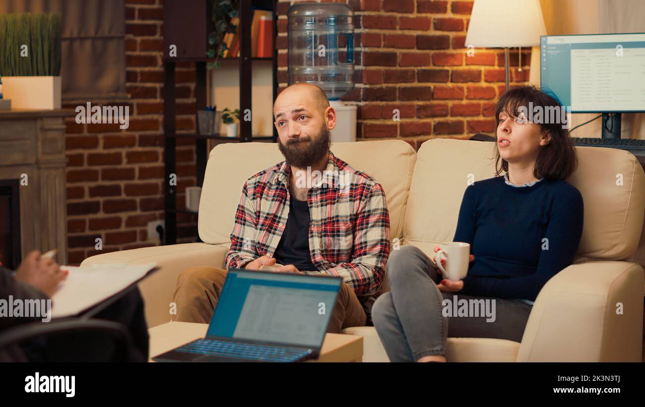 Man and woman attending couple therapy session with counselor to solve ...