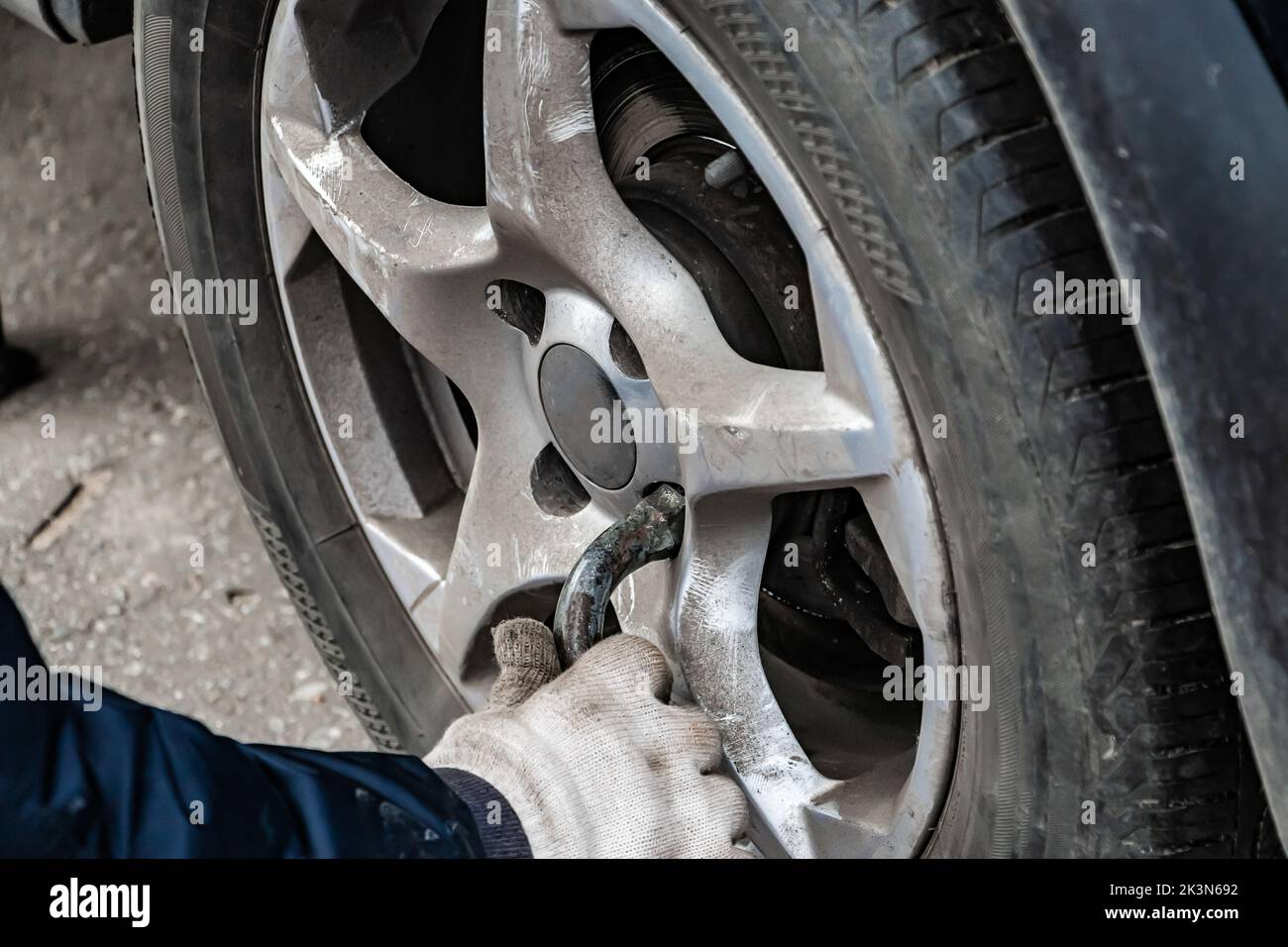 Auto mechanic changes wheel on old car. Man changes punctured tire ...