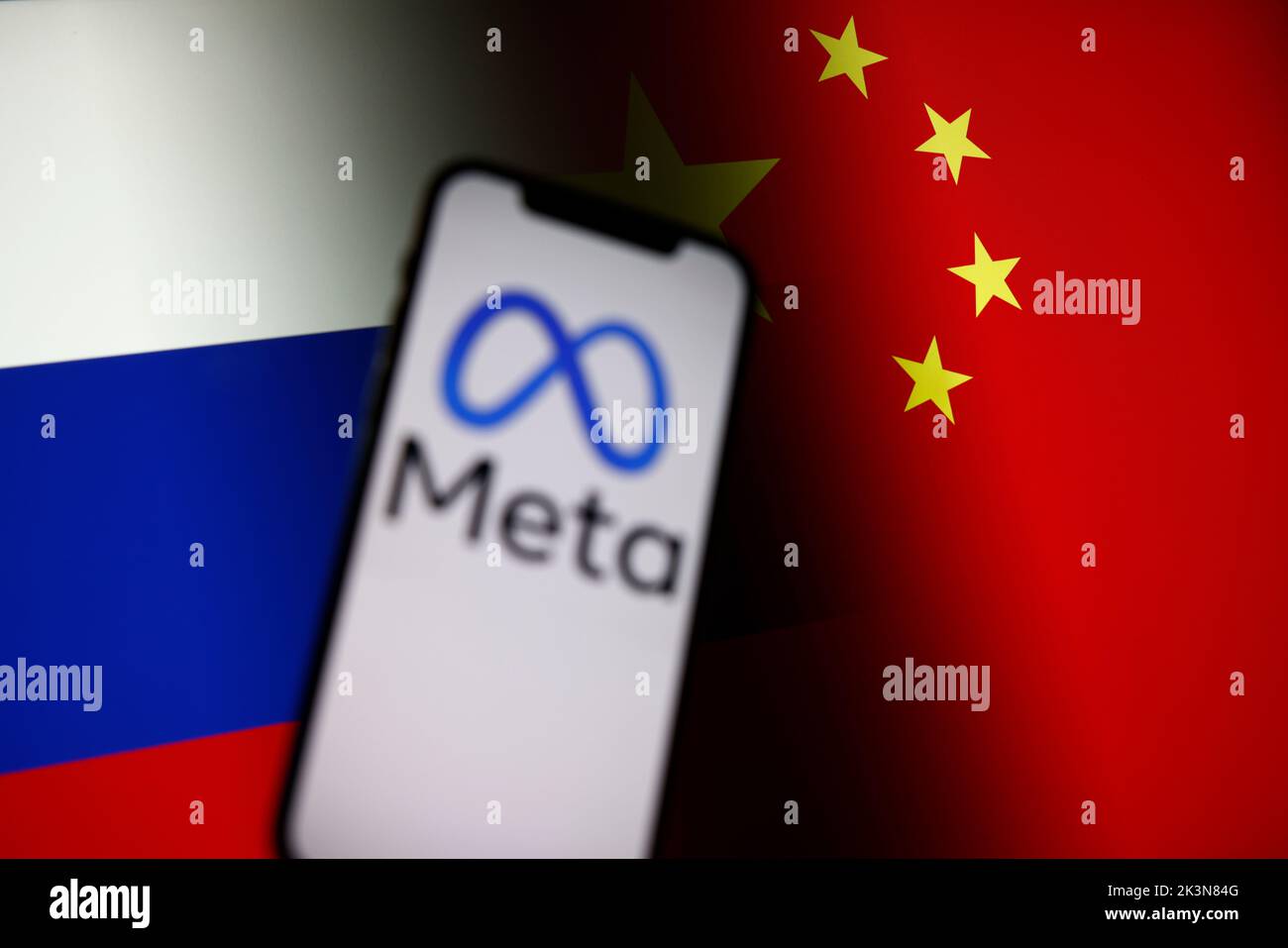 The Meta logo is seen on a mobile phone with Chinese and Russian flags ...