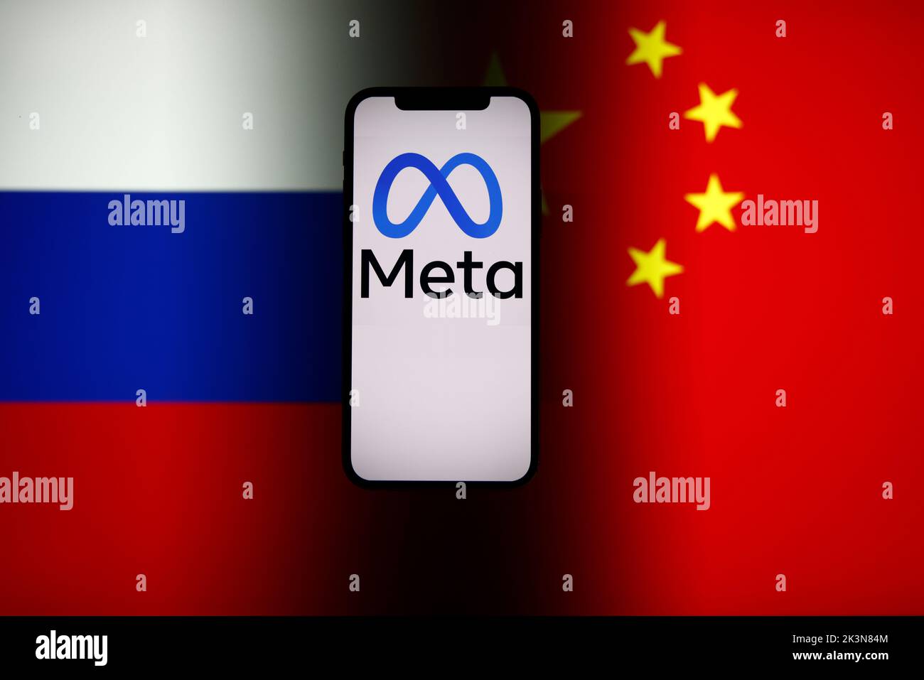 The Meta logo is seen on a mobile phone with Chinese and Russian flags ...