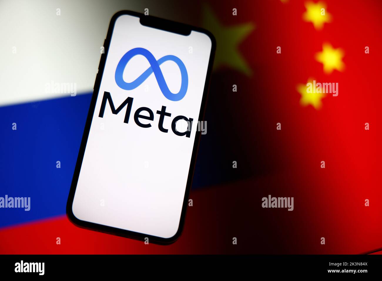 The Meta logo is seen on a mobile phone with Chinese and Russian flags ...