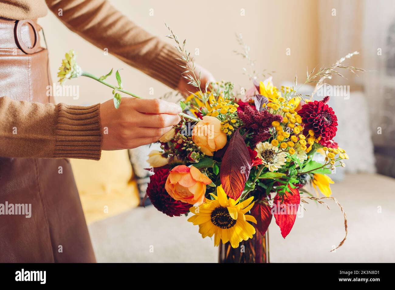 Flower arrangement. Woman makes fall bouquet of sunflowers dahlias ...