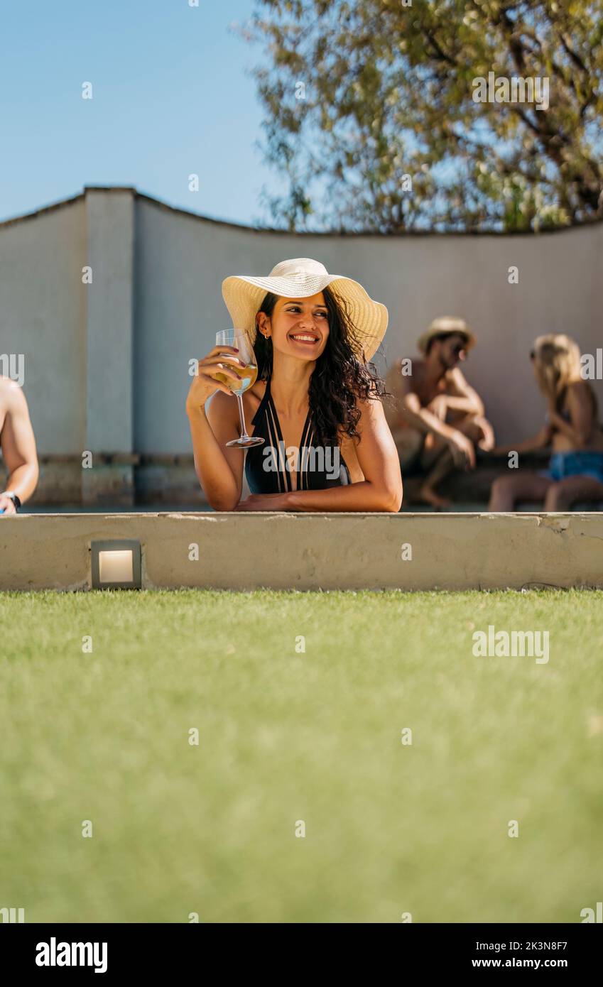 Woman leaning at the edge of swimming pool hi-res stock photography and ...