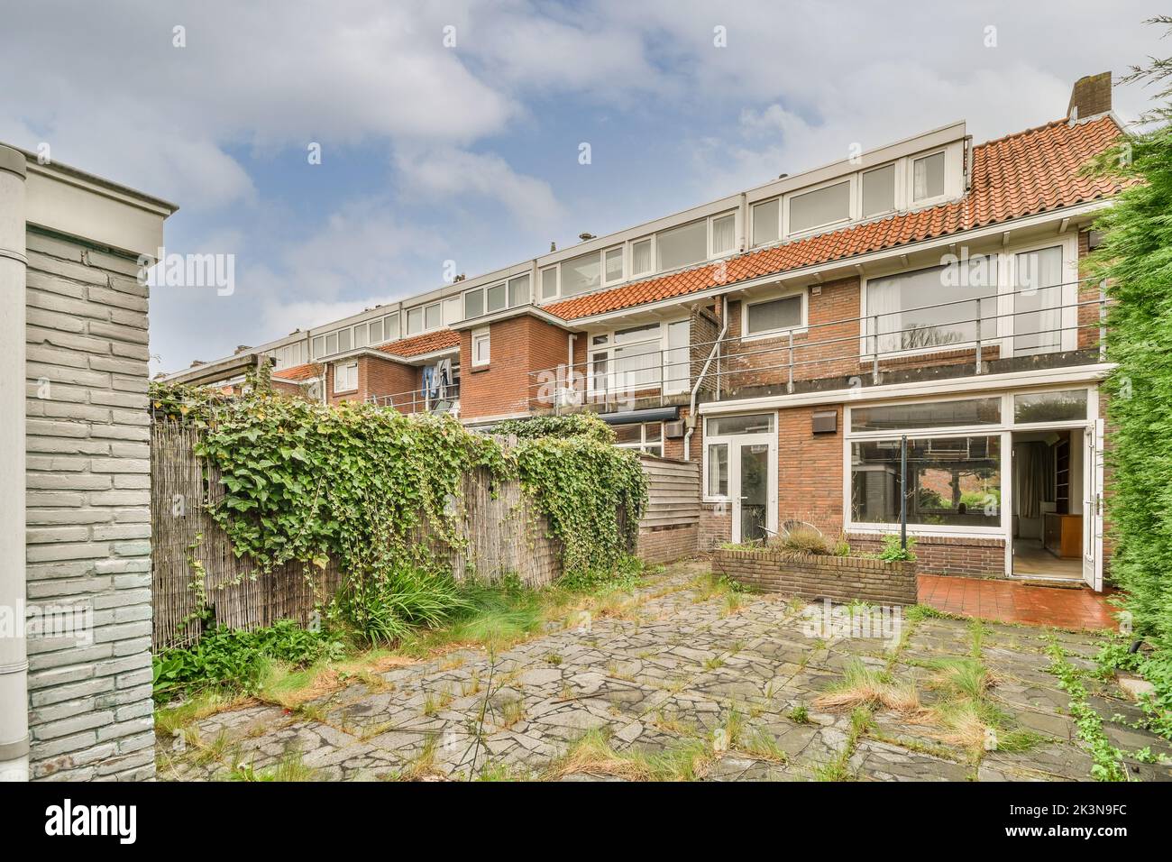 Neat powerful patio with sitting area and small garden near wooden ...