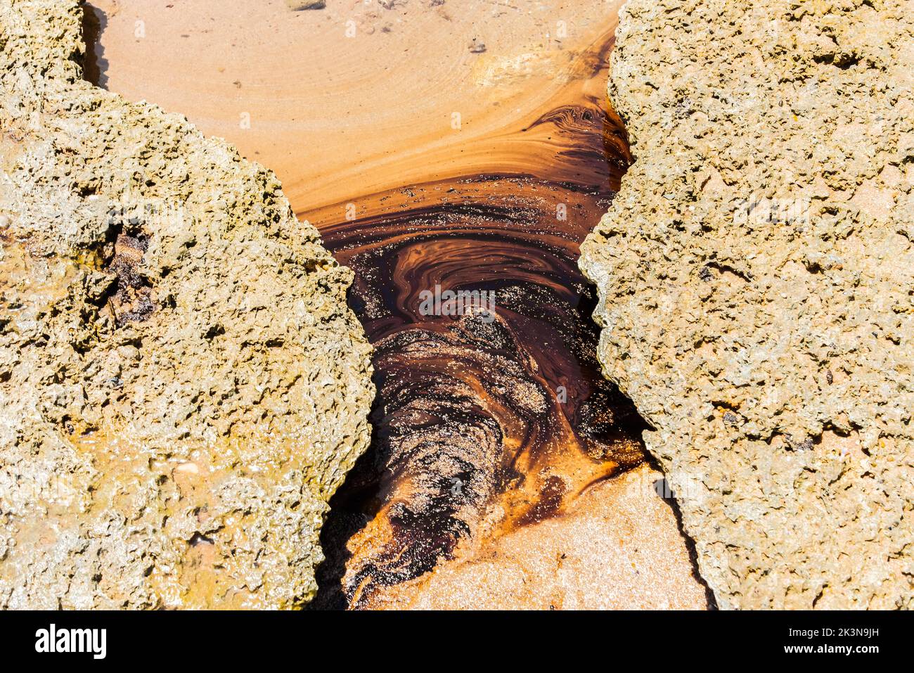 The sea beach and the rocks are polluted with oil. A crude oil spill in ...