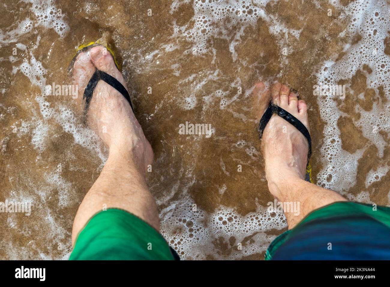 Top to bottom view of feet on the beach sand. Barra beach lighthouse ...