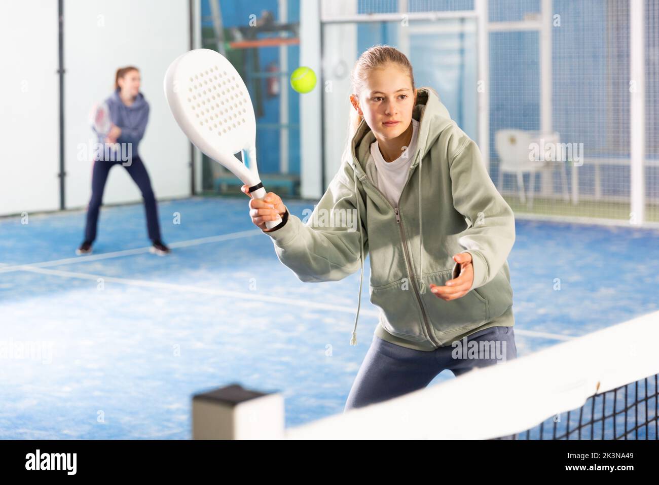 Teenage girl playing padel in court Stock Photo - Alamy