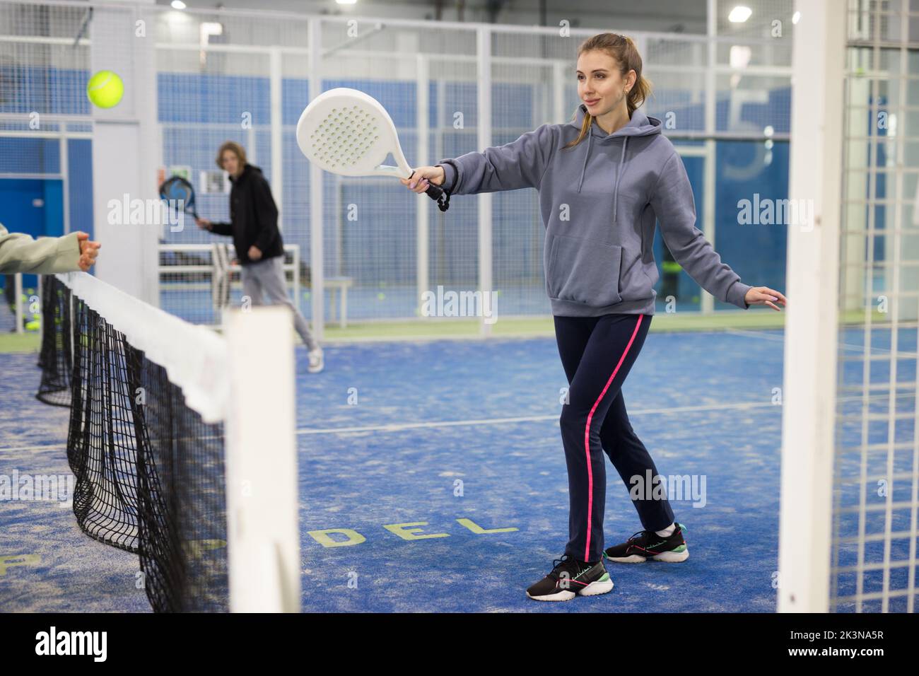Woman and man learning to play padel on tennis court Stock Photo - Alamy