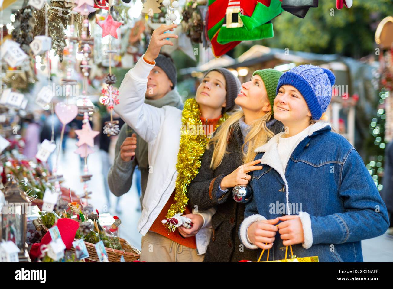 Family of four choosing decorations at Christmas fair Stock Photo - Alamy