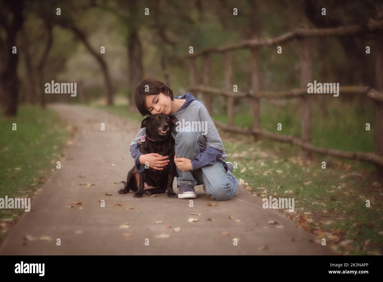 Boy Hugging Dog In Path Stock Photo - Alamy