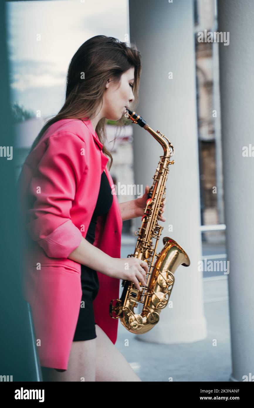 young girl playing the saxophone on the city street Stock Photo - Alamy